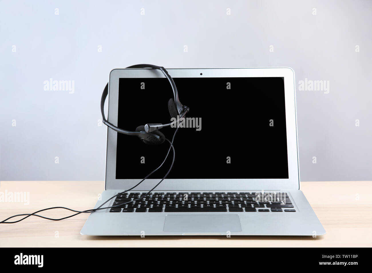 Laptop with headset on white table Stock Photo - Alamy