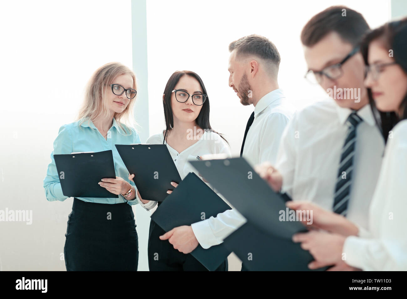 close up.employees read business documents standing Stock Photo - Alamy