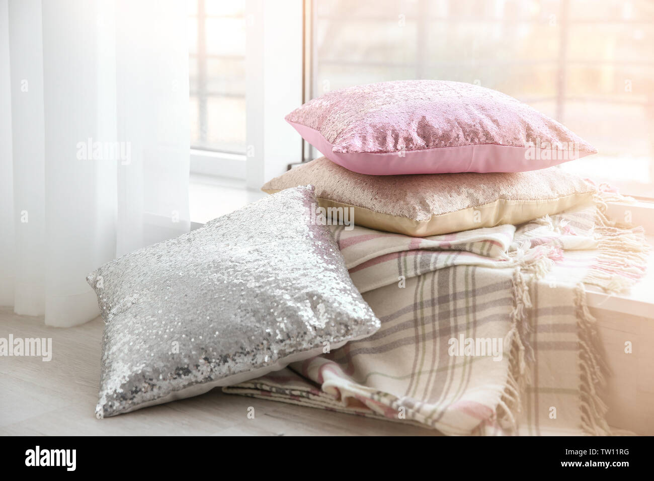 Three shiny glamorous pillows on windowsill Stock Photo - Alamy