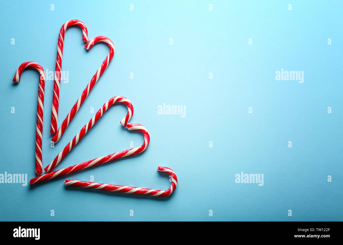 Sweet candy canes on light blue background Stock Photo - Alamy