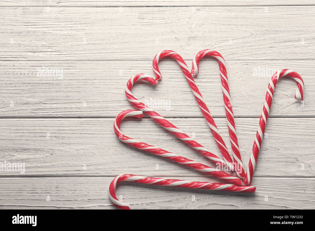 Sweet candy canes on wooden background Stock Photo - Alamy