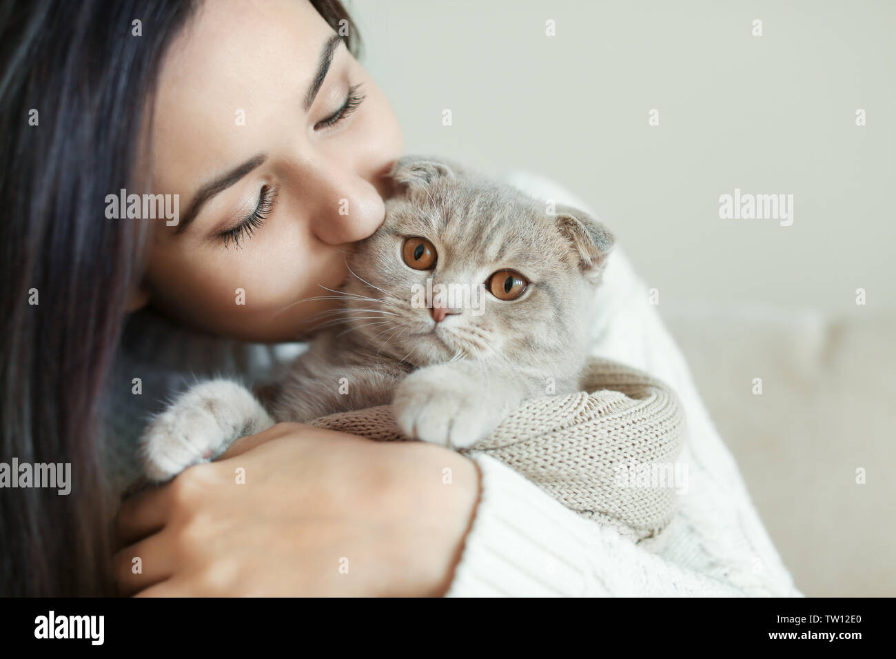 Beautiful young woman with cute cat resting at home Stock Photo - Alamy