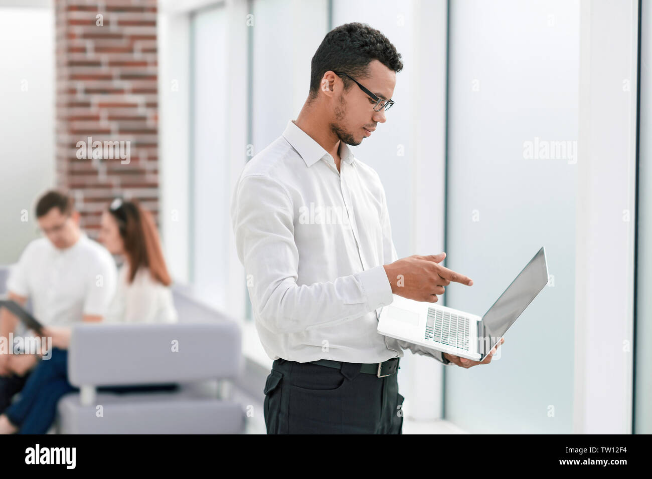 employee typing on a laptop standing in the office. people and ...
