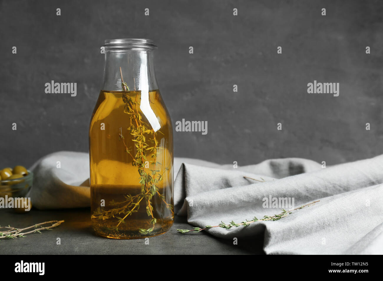 Olive oil with herbs on dark texture background Stock Photo - Alamy