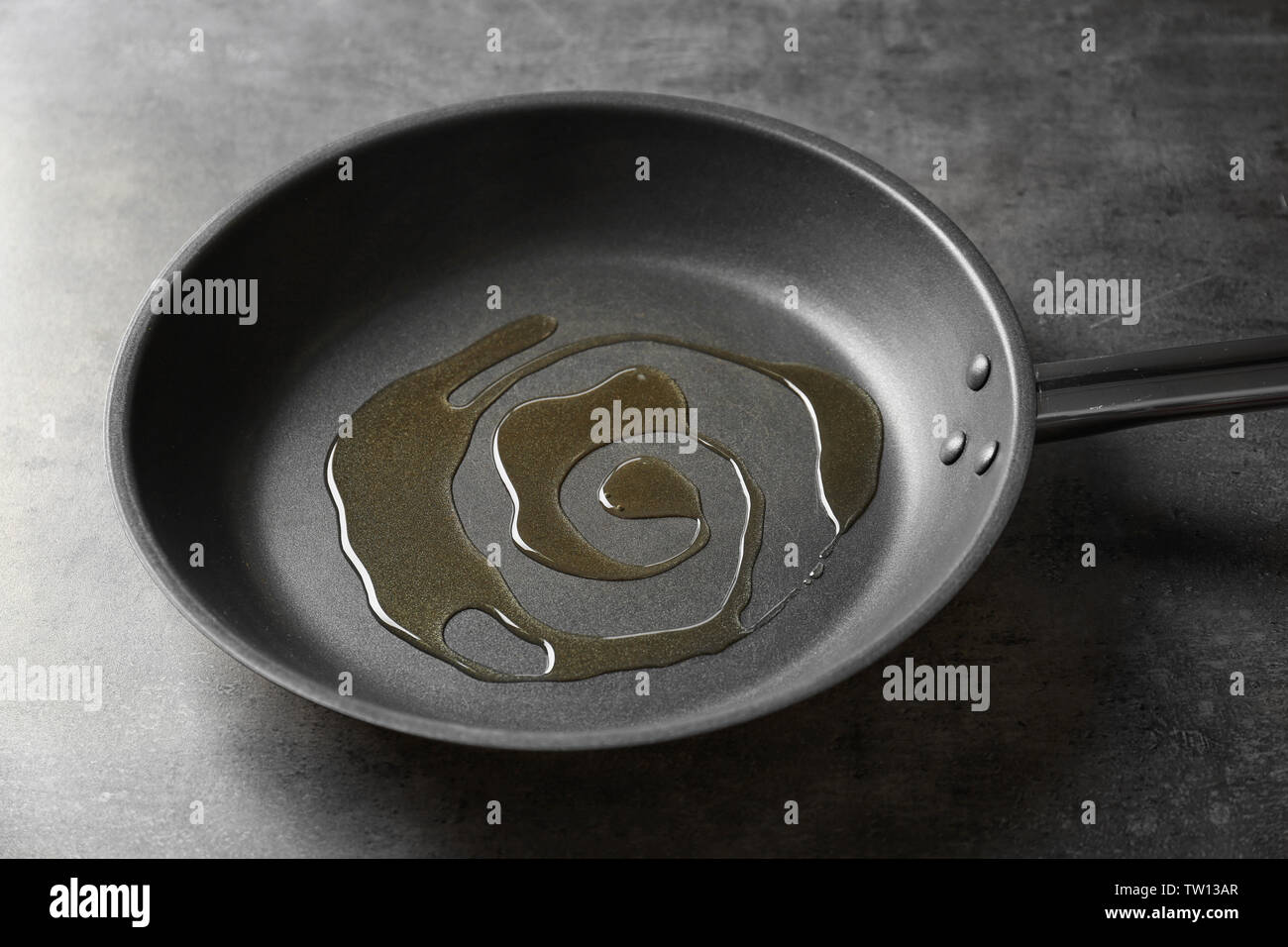 Pan with oil on gray background Stock Photo - Alamy