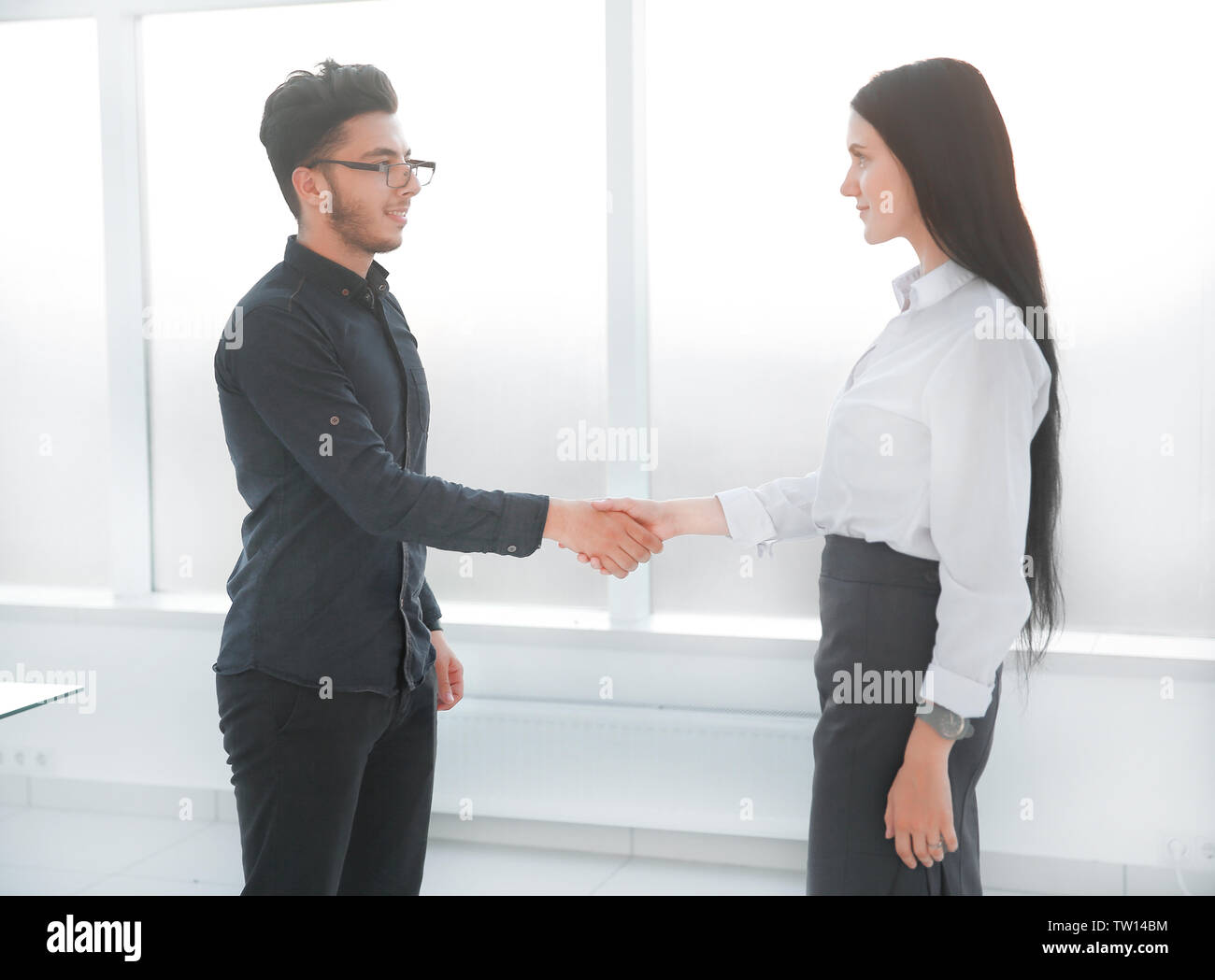 business partners shake hands standing in the office.concept of ...