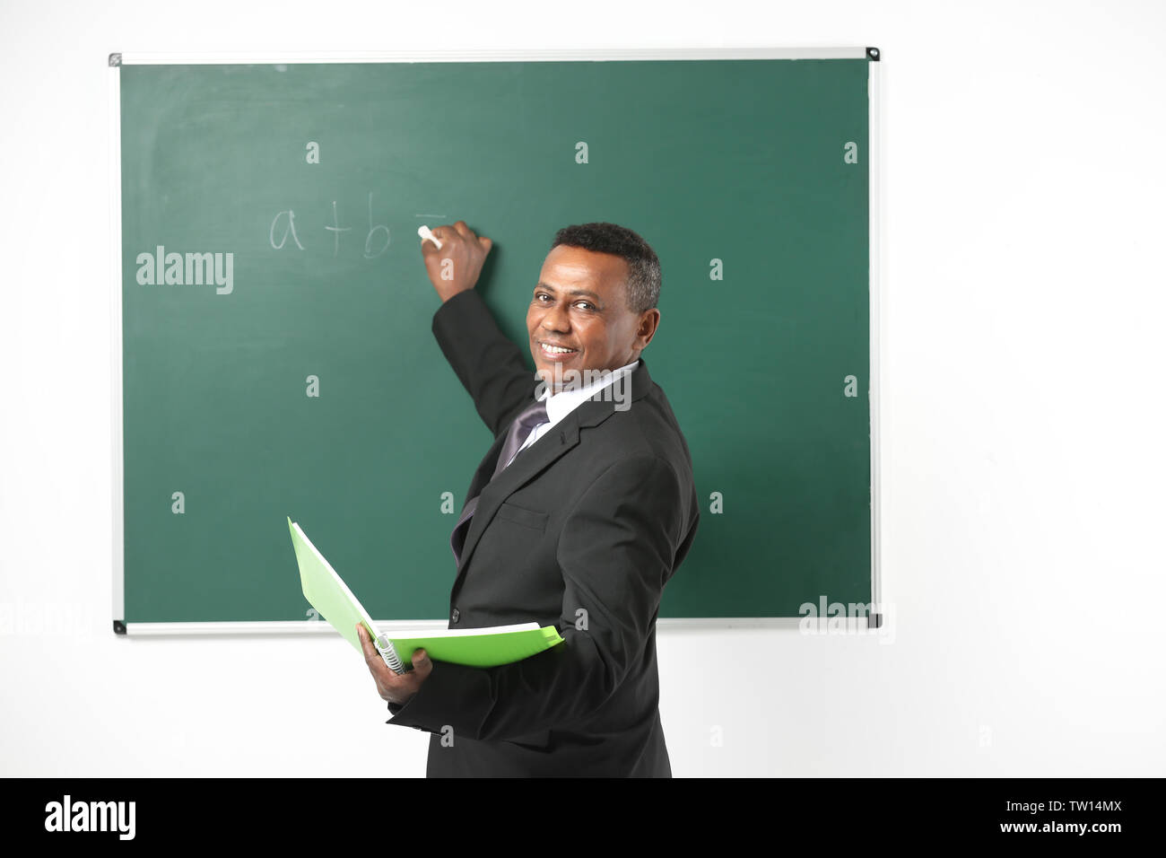 Indian teacher writing on blackboard in classroom Stock Photo - Alamy