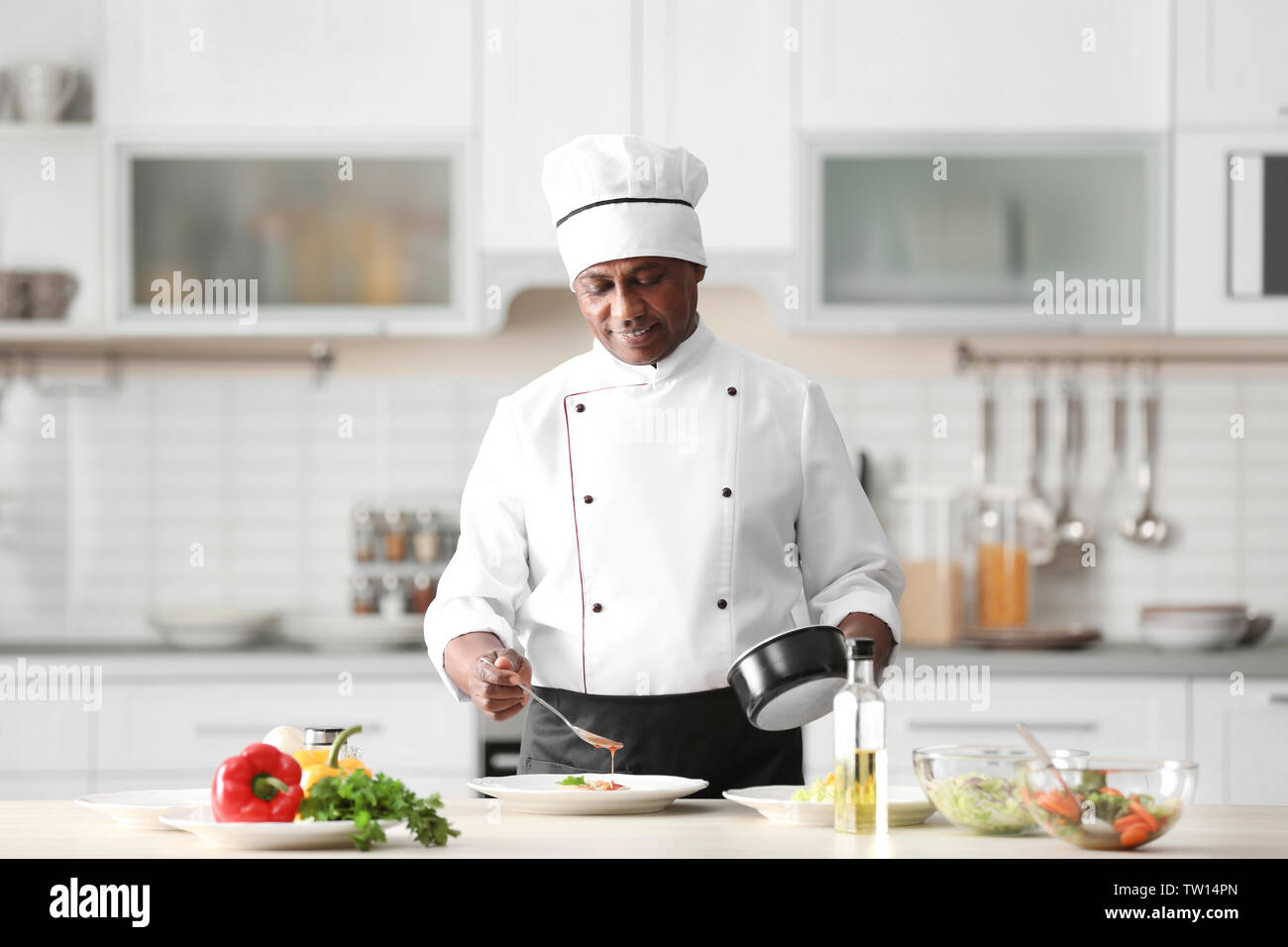Mature Indian chef cooking in kitchen Stock Photo - Alamy