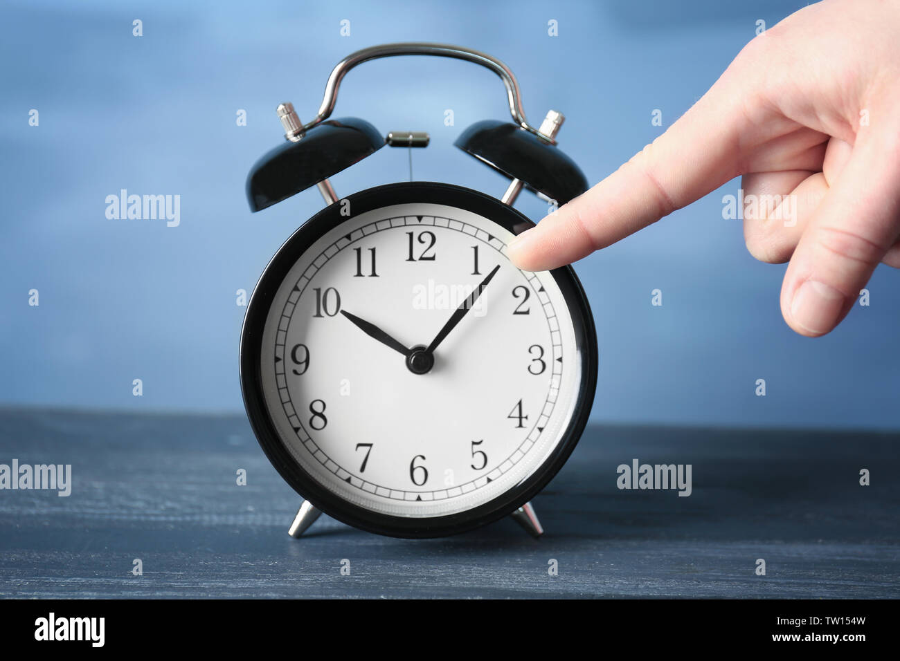 Female hand pointing on alarm clock, closeup Stock Photo - Alamy