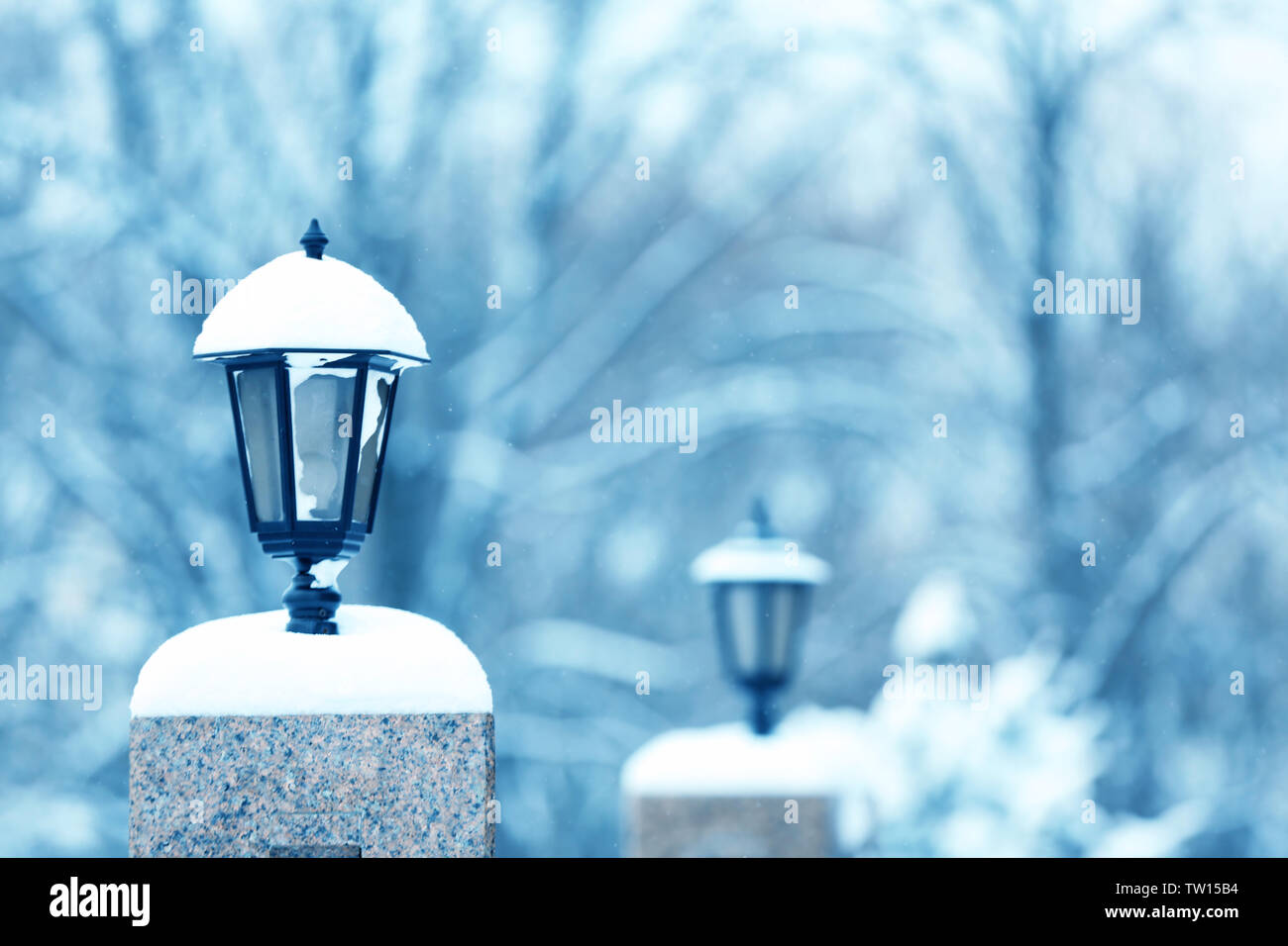 Snow covered street light on winter park background Stock Photo - Alamy