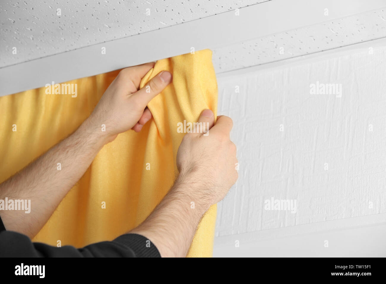 Male hands installing curtains over window Stock Photo - Alamy
