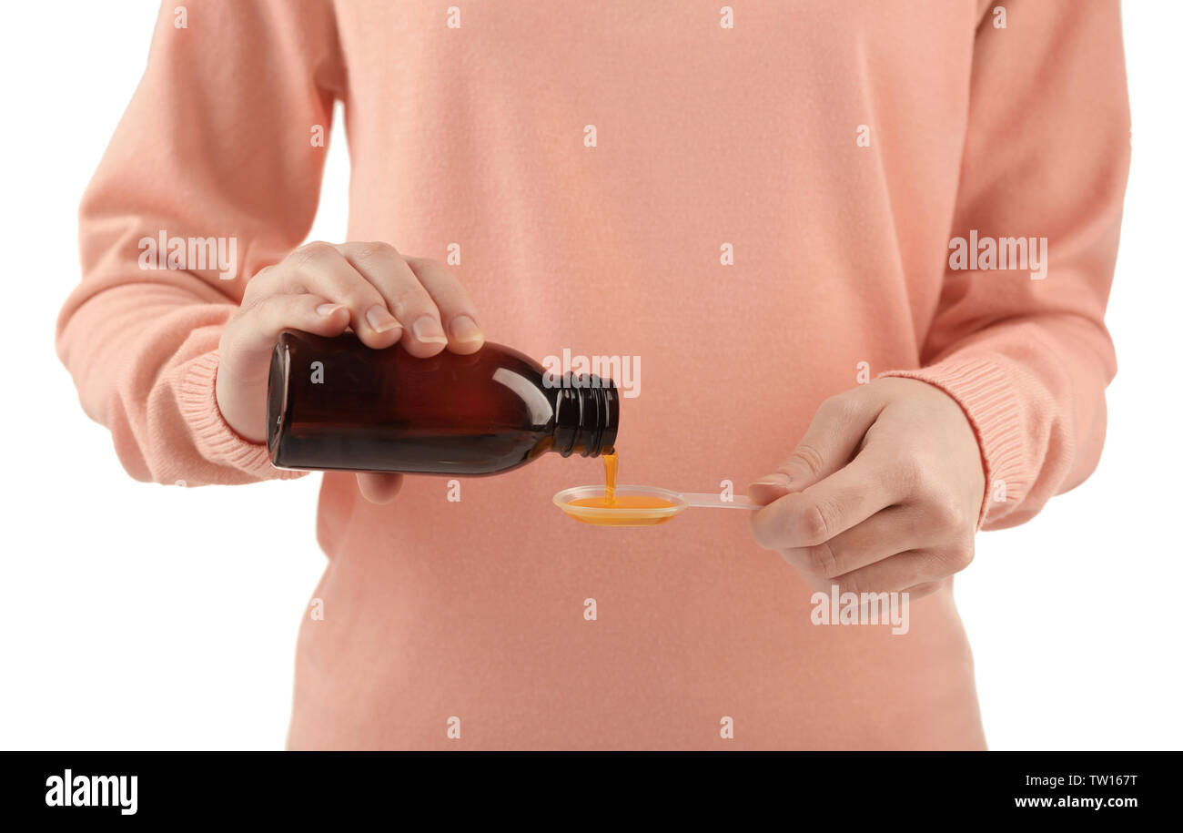 Woman pouring cough medicine syrup into spoon on white background Stock ...