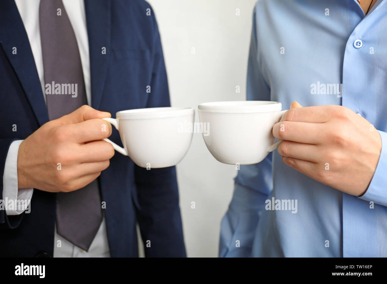 Blank white cups in hands, closeup Stock Photo - Alamy