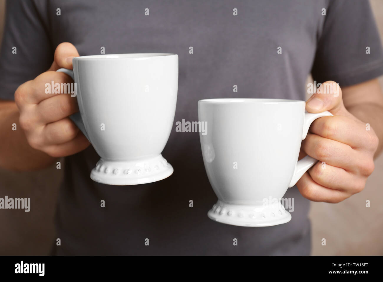 Blank white cups in hands, closeup Stock Photo - Alamy