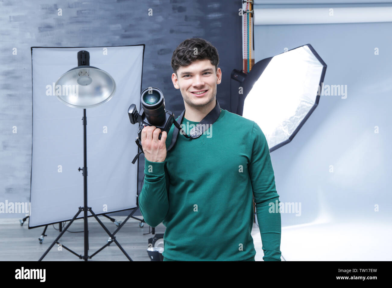 Young professional photographer with camera in studio Stock Photo - Alamy