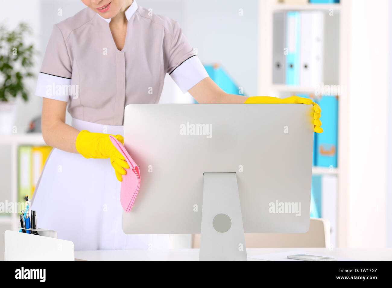 Beautiful chambermaid cleaning computer monitor at office Stock Photo ...