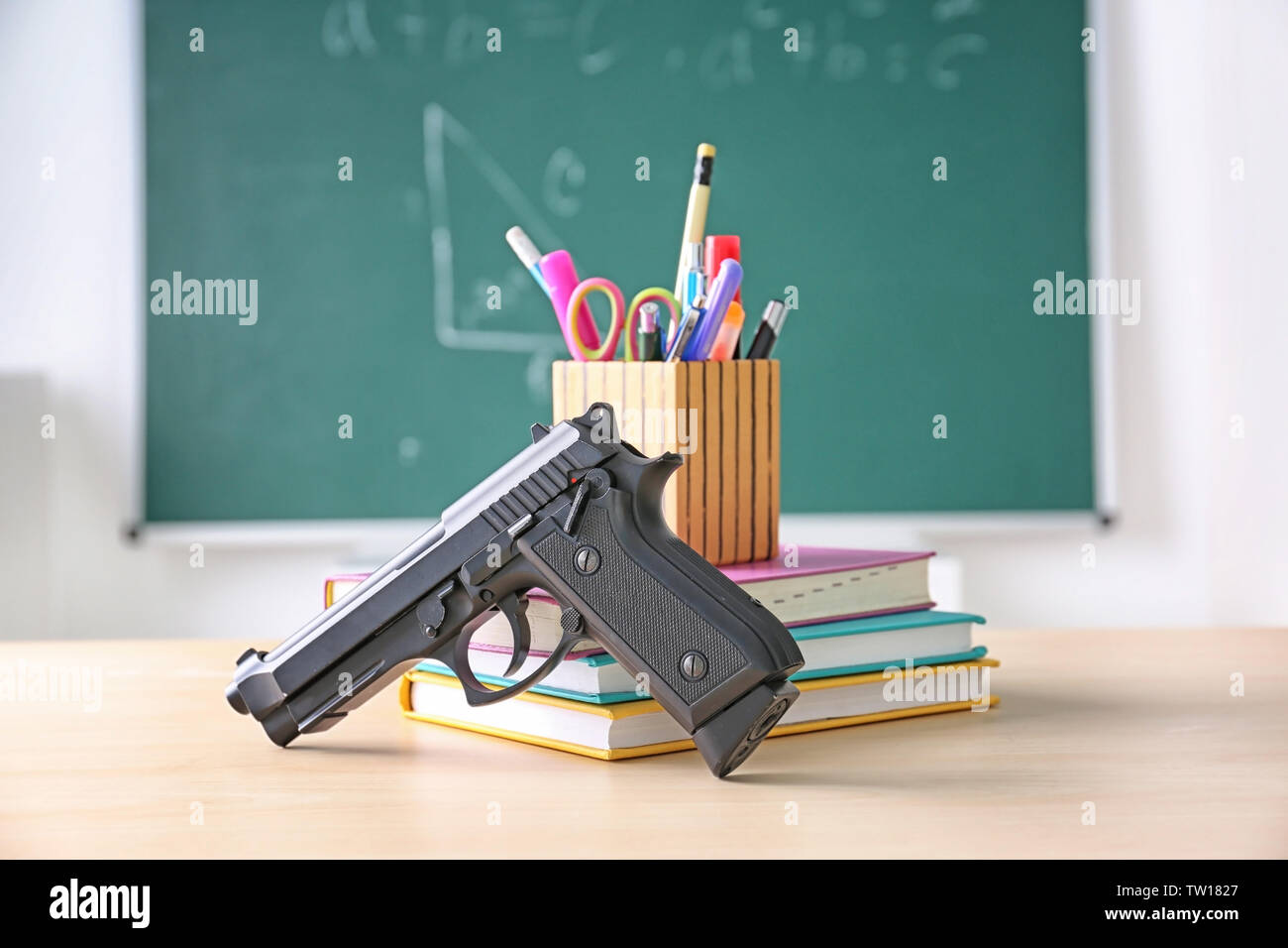 School stationery and gun on table in class Stock Photo - Alamy