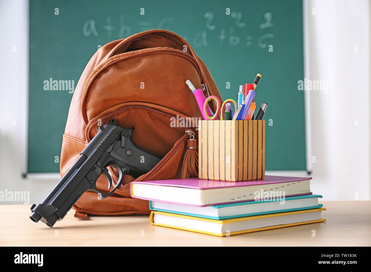 School stationery and gun on table in class Stock Photo - Alamy