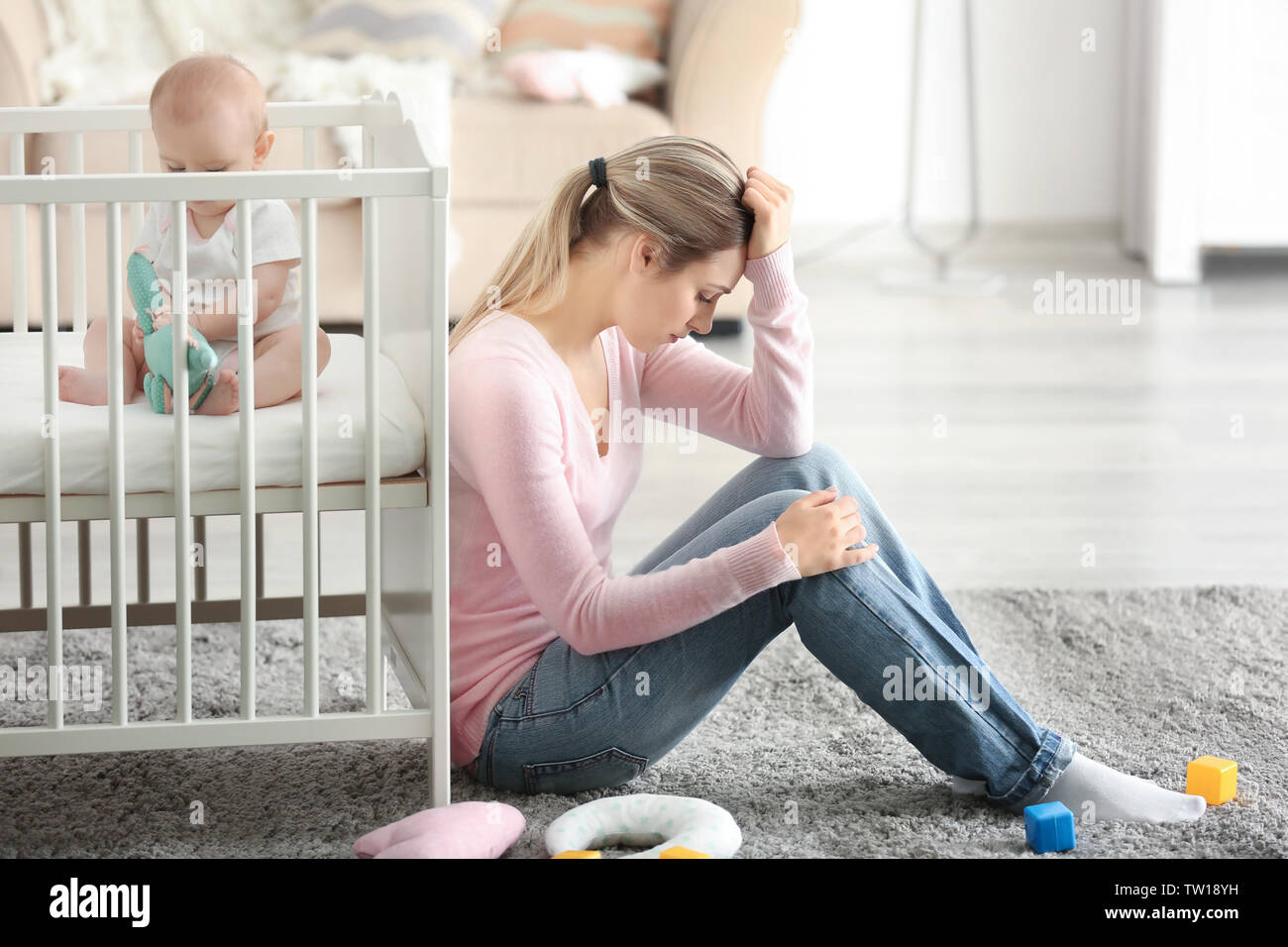 Depressed young woman with cute baby at home Stock Photo - Alamy