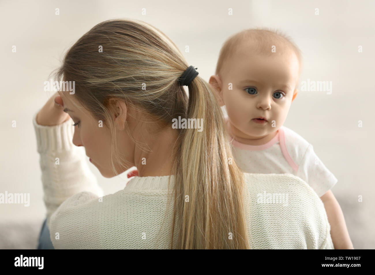 Depressed young woman with cute baby at home Stock Photo - Alamy