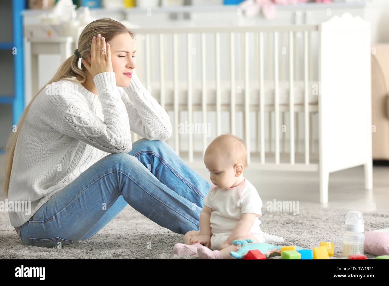 Depressed young woman with cute baby at home Stock Photo - Alamy