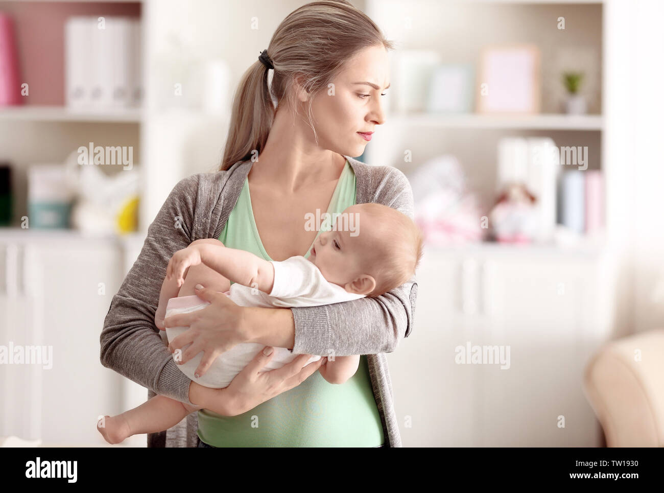 Depressed young woman with cute baby at home Stock Photo - Alamy