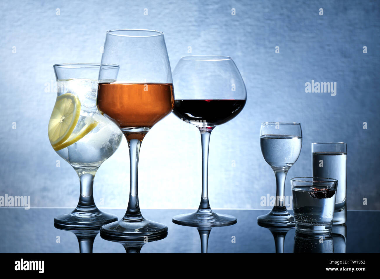 Different glasses of wine and spirits on color background Stock Photo ...