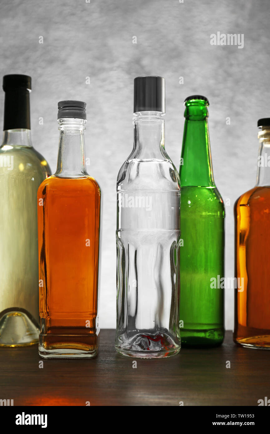 Different bottles of wine and spirits on color background Stock Photo ...