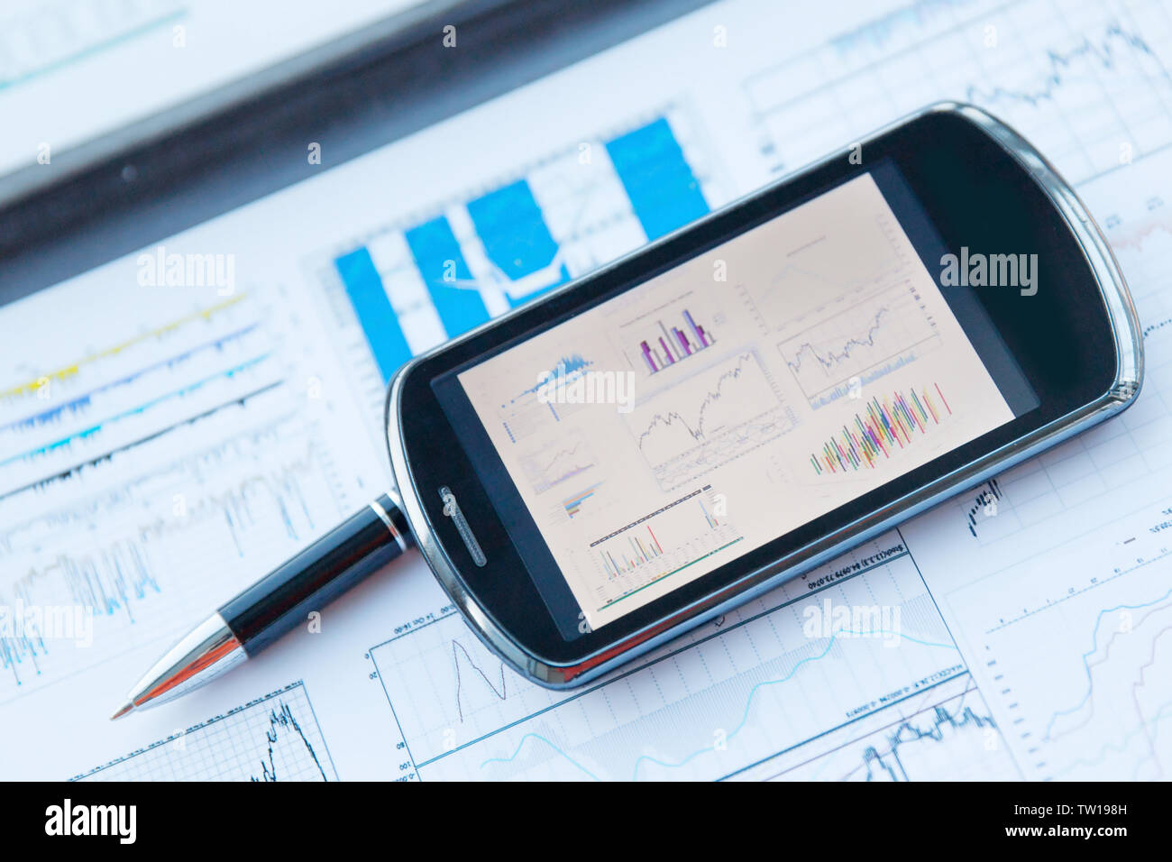 mobile phones and charts of financial growth on the desktop . business ...