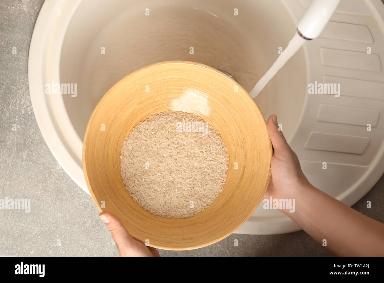 Woman rinsing rice in bowl Stock Photo - Alamy