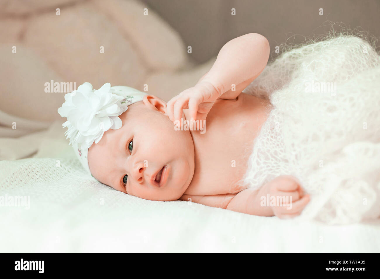 newborn baby girl in a beautiful bonnet lying on a blanket. photo with ...