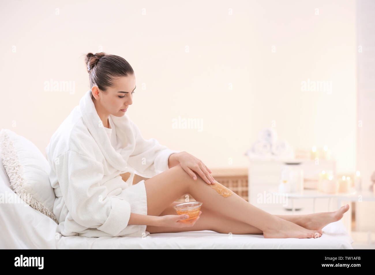 Young woman depilating legs with liquid sugar in spa center Stock Photo ...