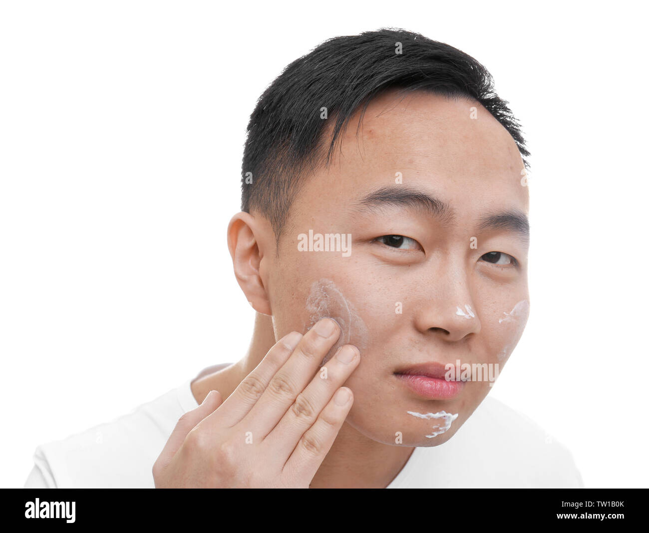 Young Asian man applying cream for problem skin onto face, on white ...