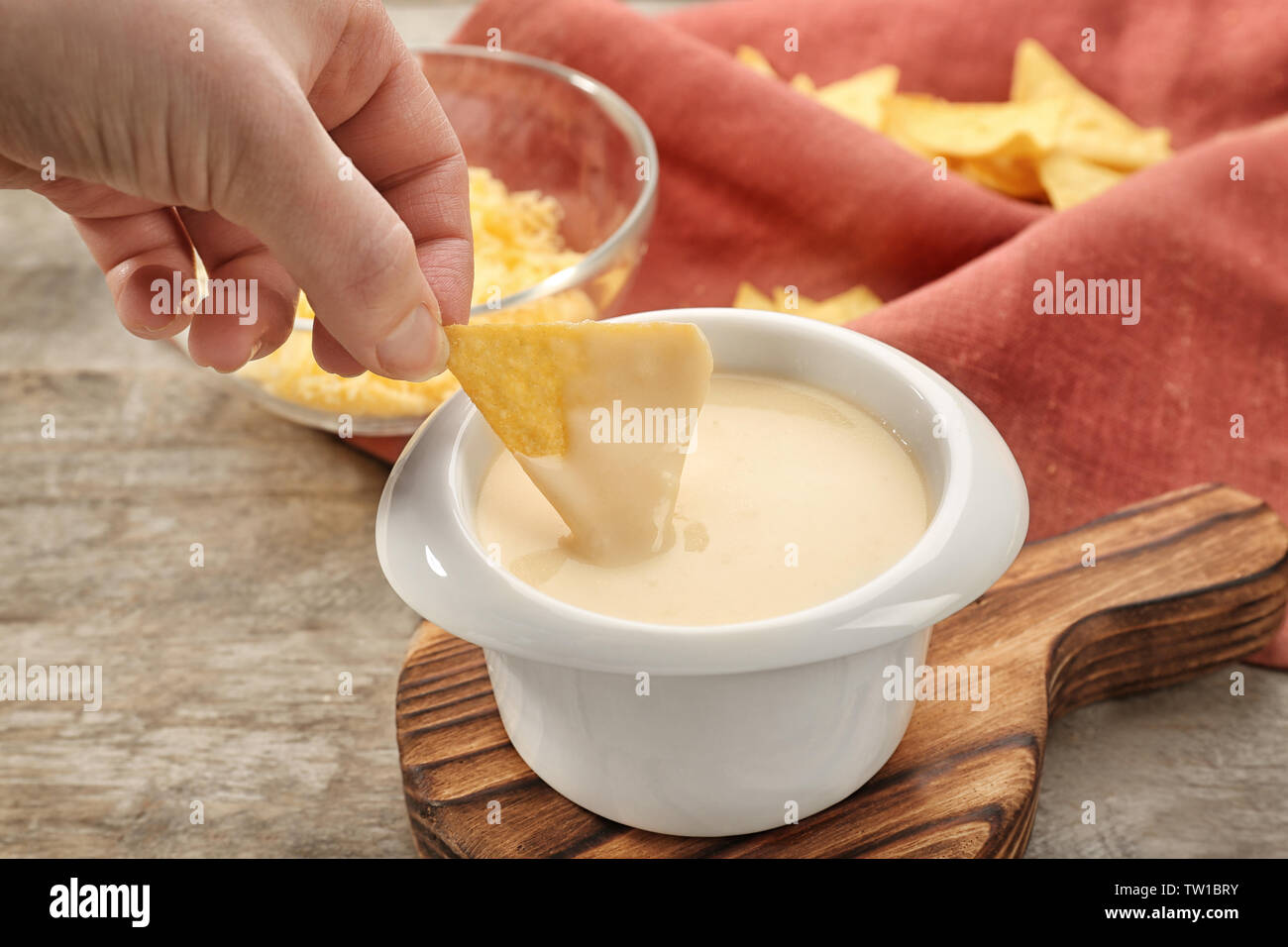 Female hand dipping nacho in bowl with beer cheese dip, closeup Stock ...