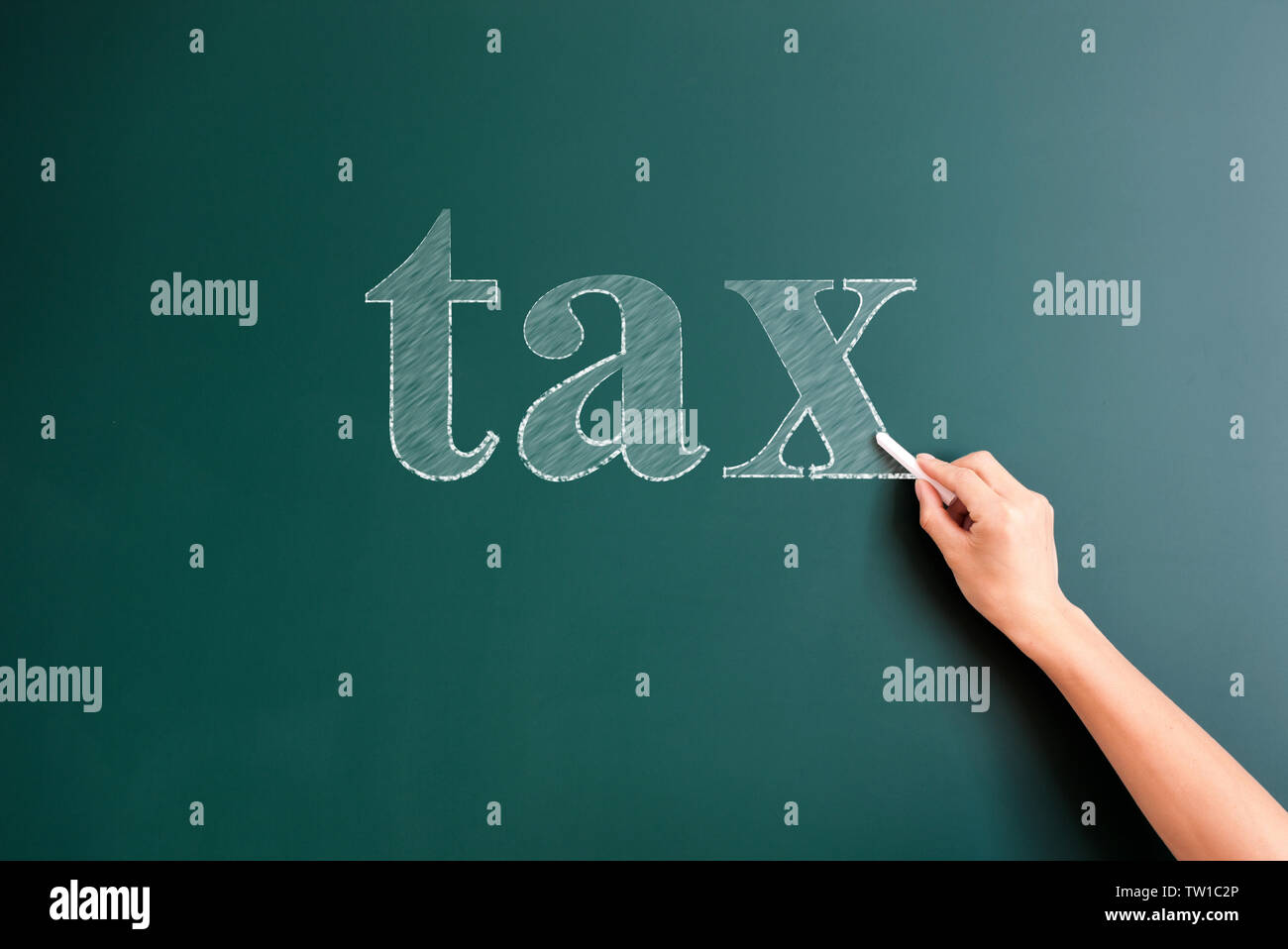 Tax written on blackboard Stock Photo - Alamy