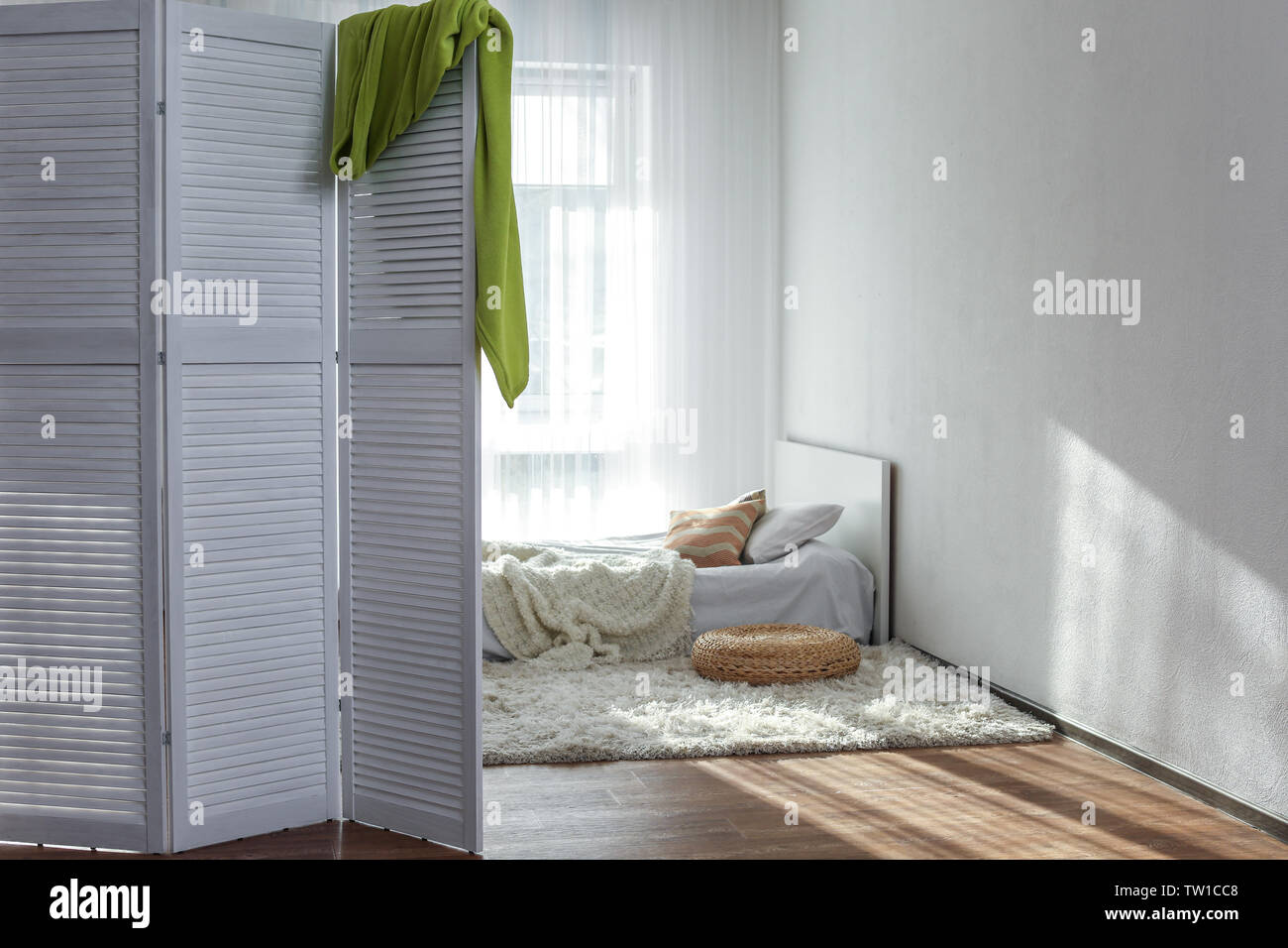 Interior of beautiful room with folding screen and bed Stock Photo - Alamy