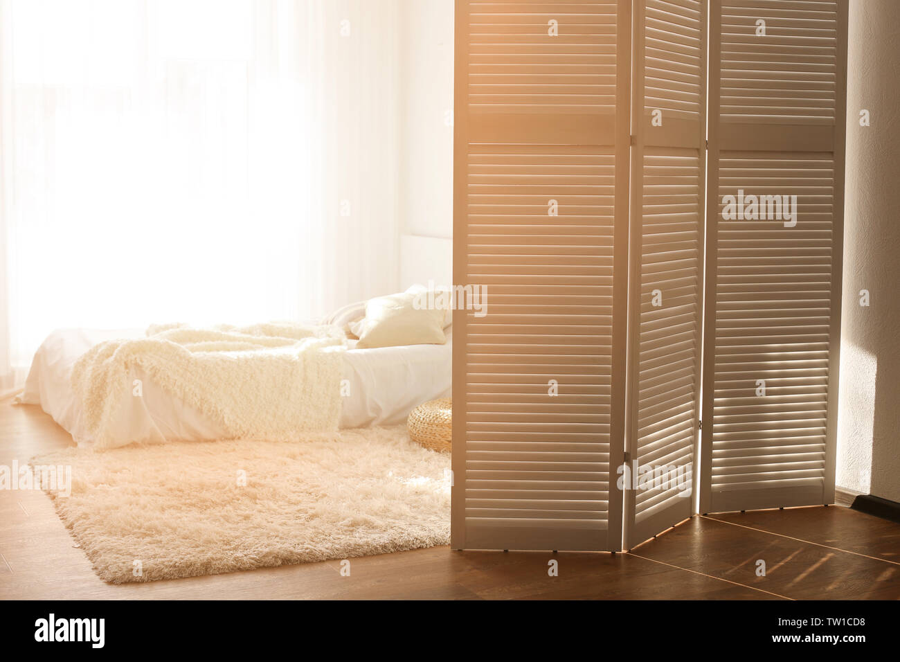 Interior of beautiful room with folding screen and bed Stock Photo - Alamy