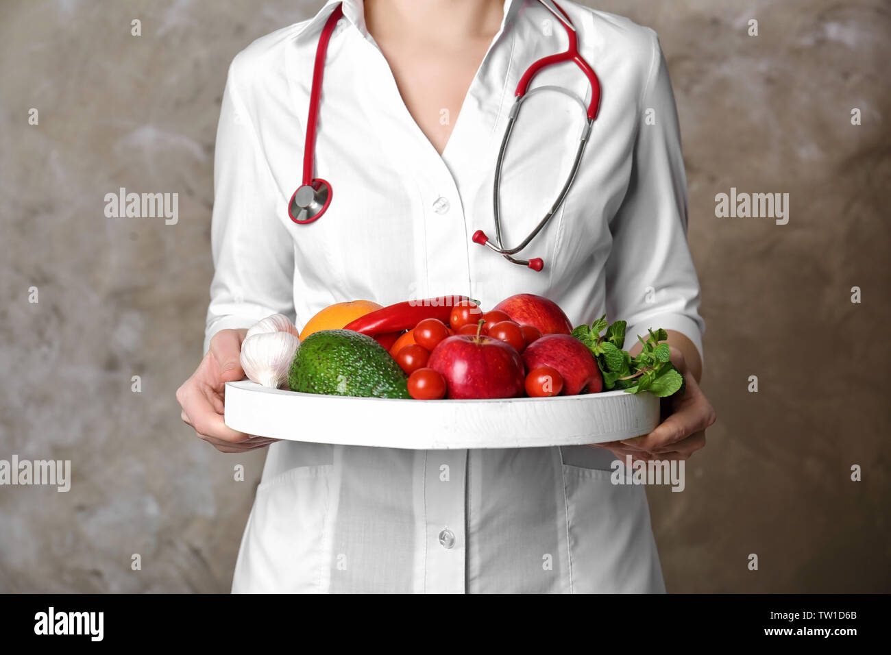 Doctor holding tray with heart healthy foods on color background Stock ...