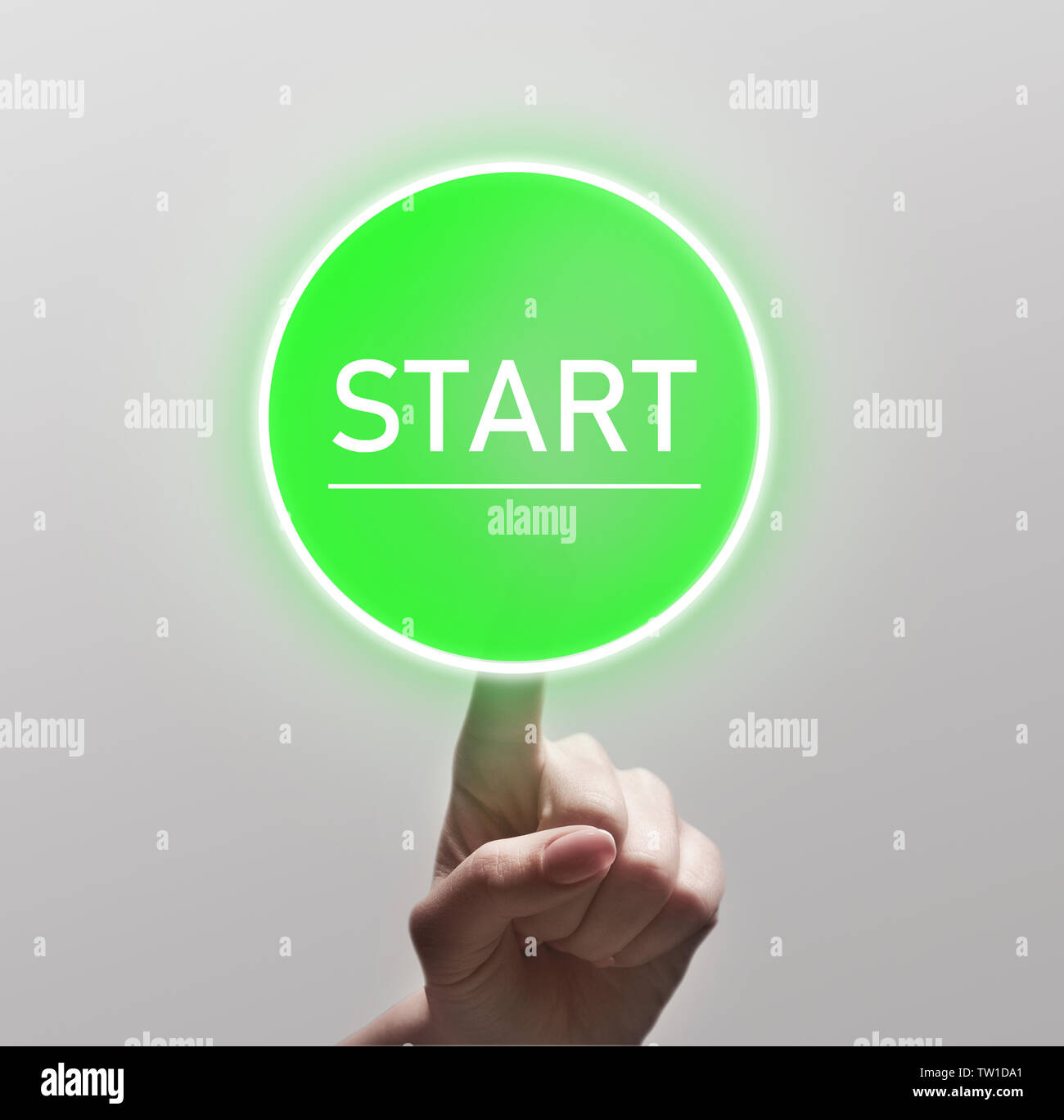 Finger touching green start button on light background, copy space ...