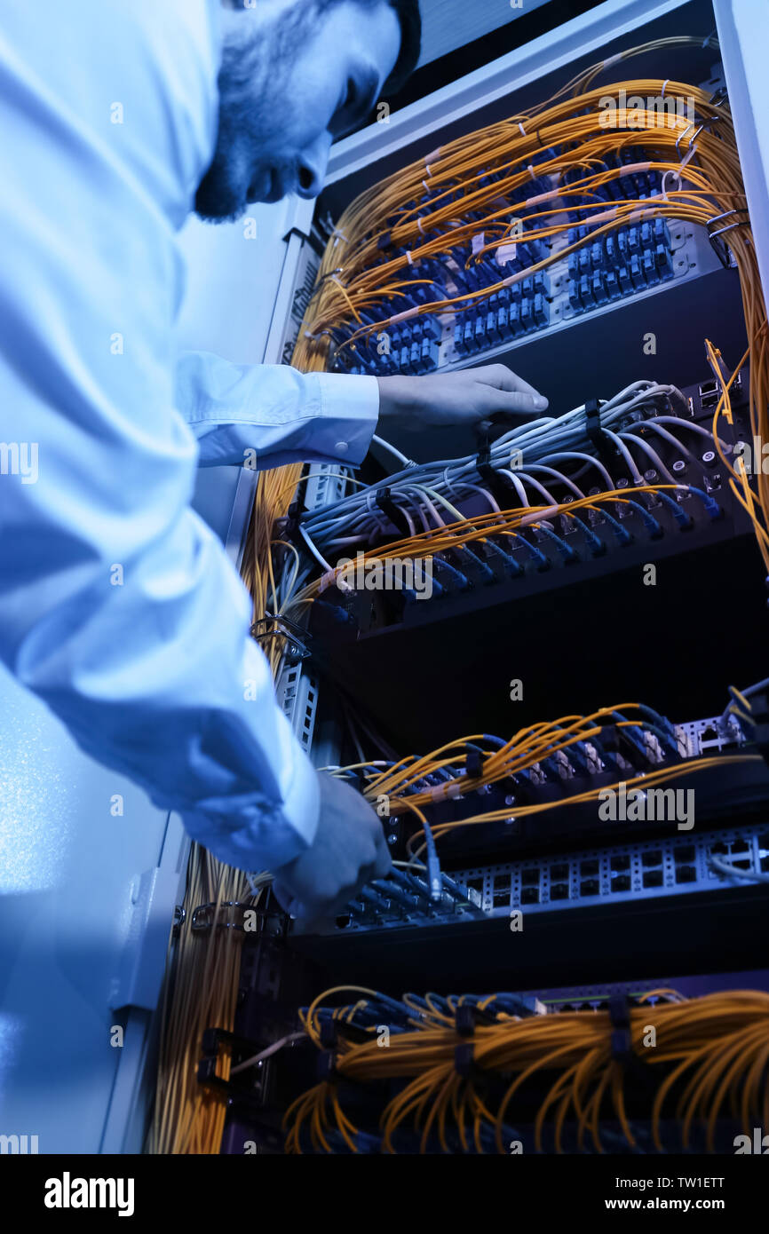 Handsome young engineer working in server room Stock Photo - Alamy
