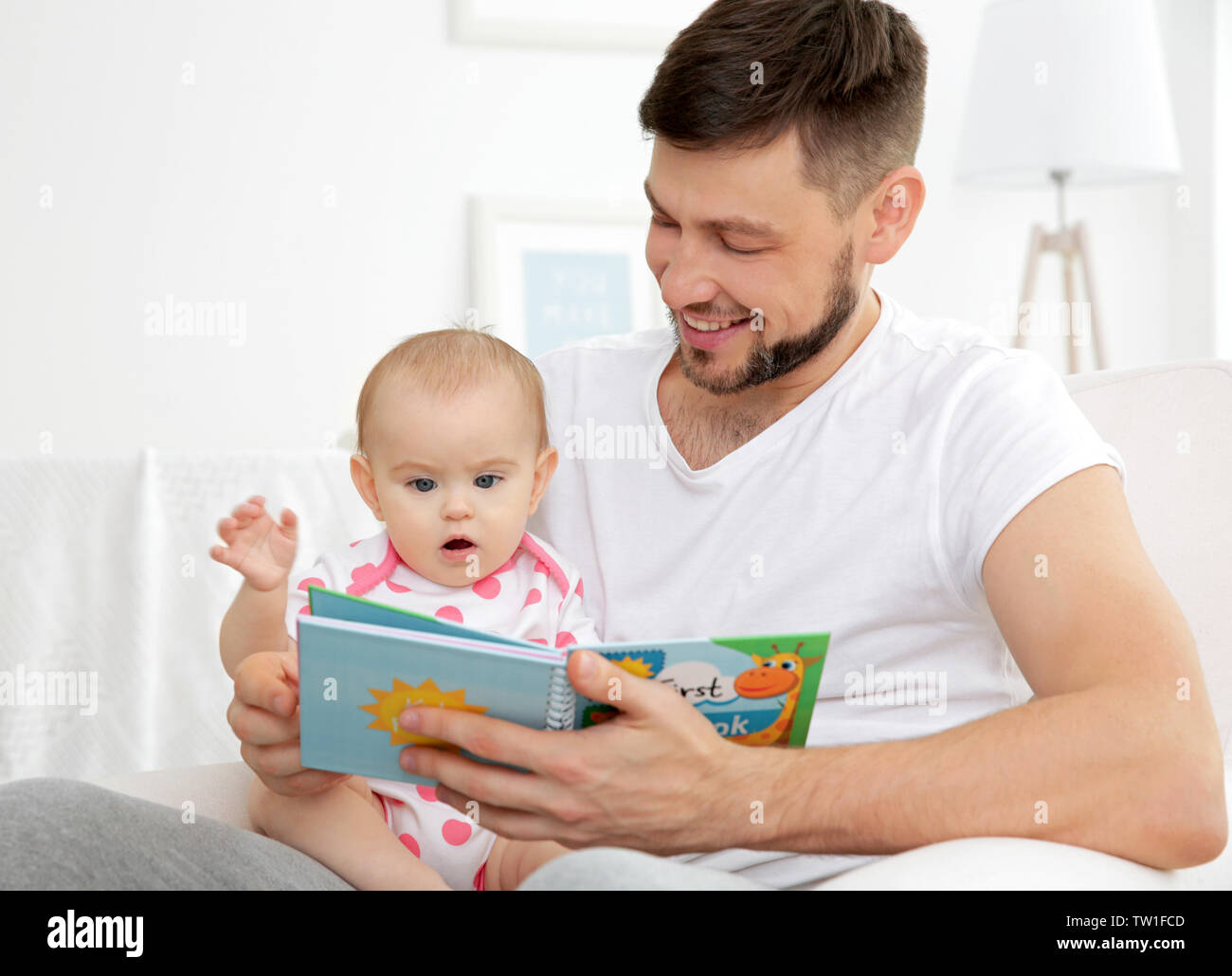 Father showing book to cute baby daughter at home Stock Photo - Alamy