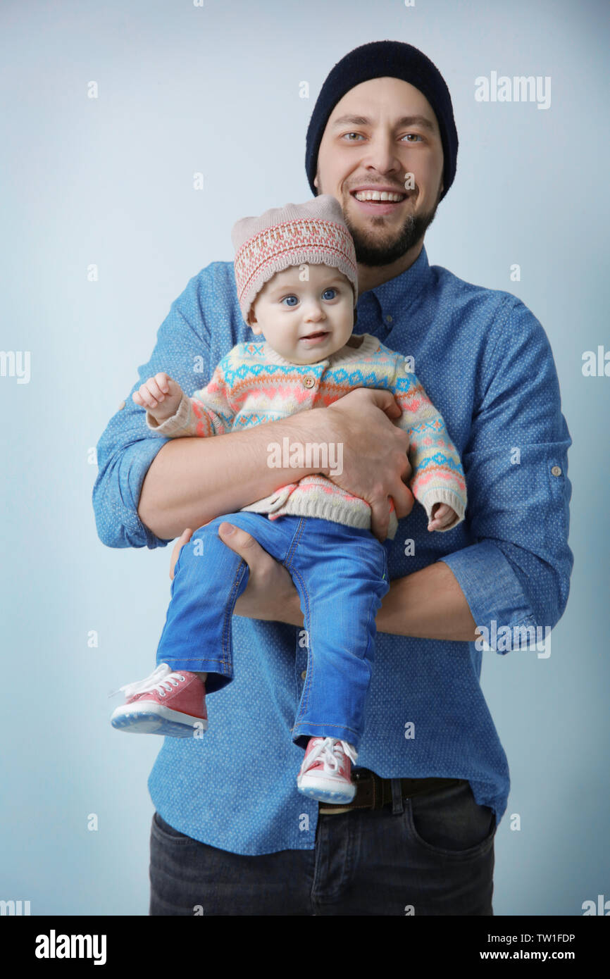 Father posing with cute baby daughter on light background Stock Photo ...