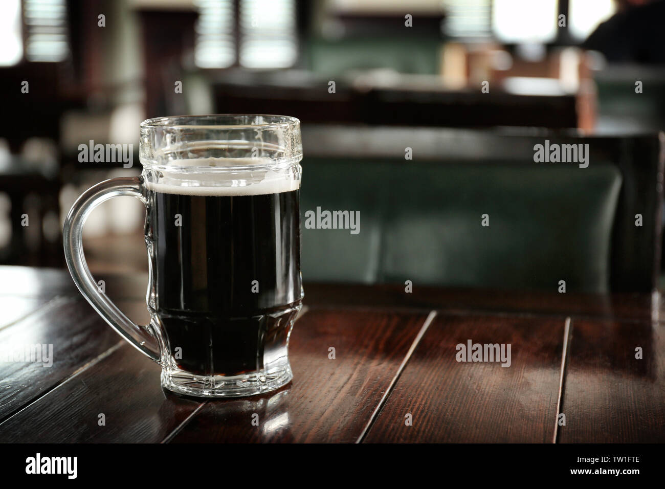 Glass of beer on table in pub Stock Photo - Alamy