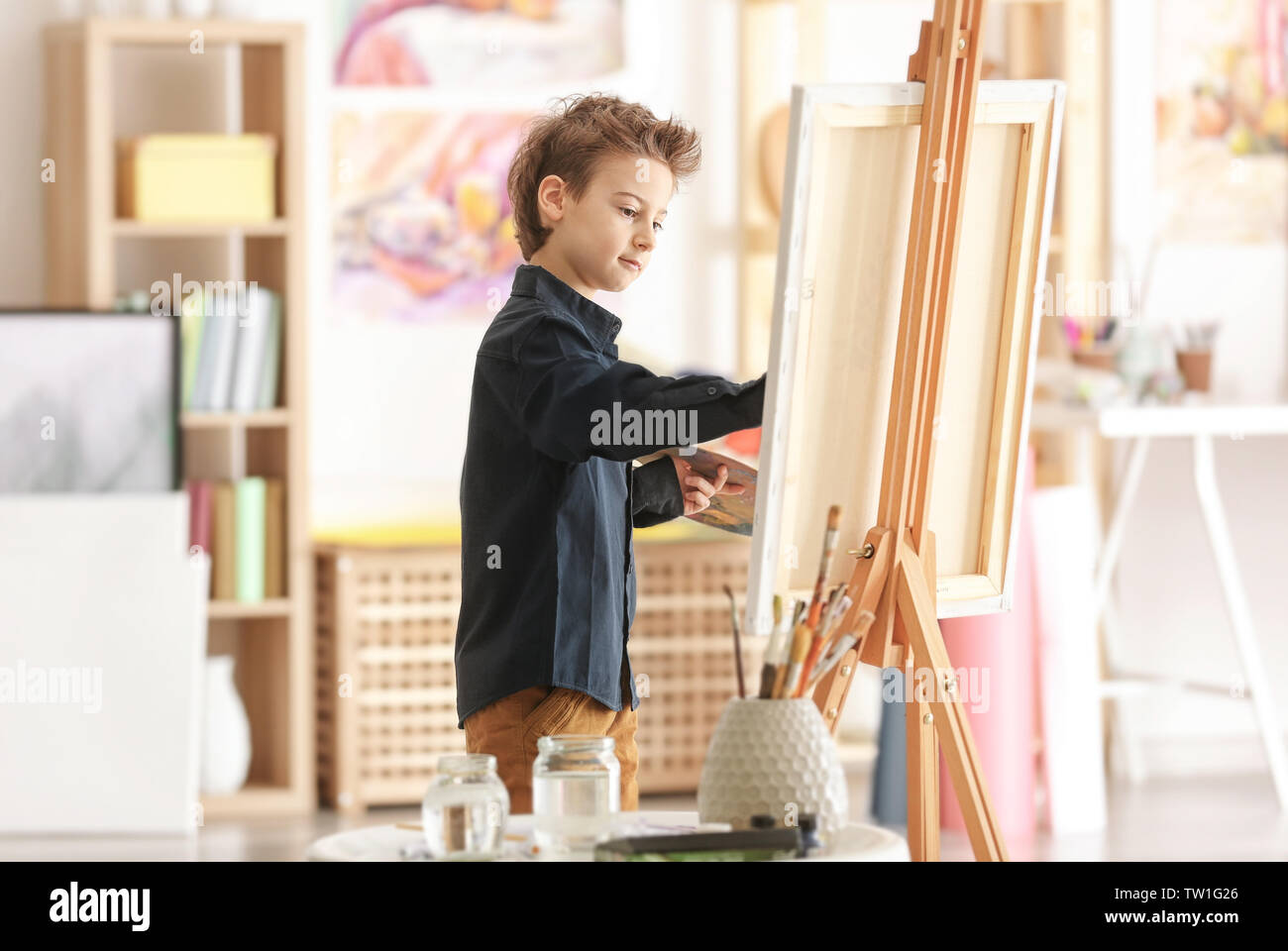 Cute little artist painting picture in studio Stock Photo - Alamy