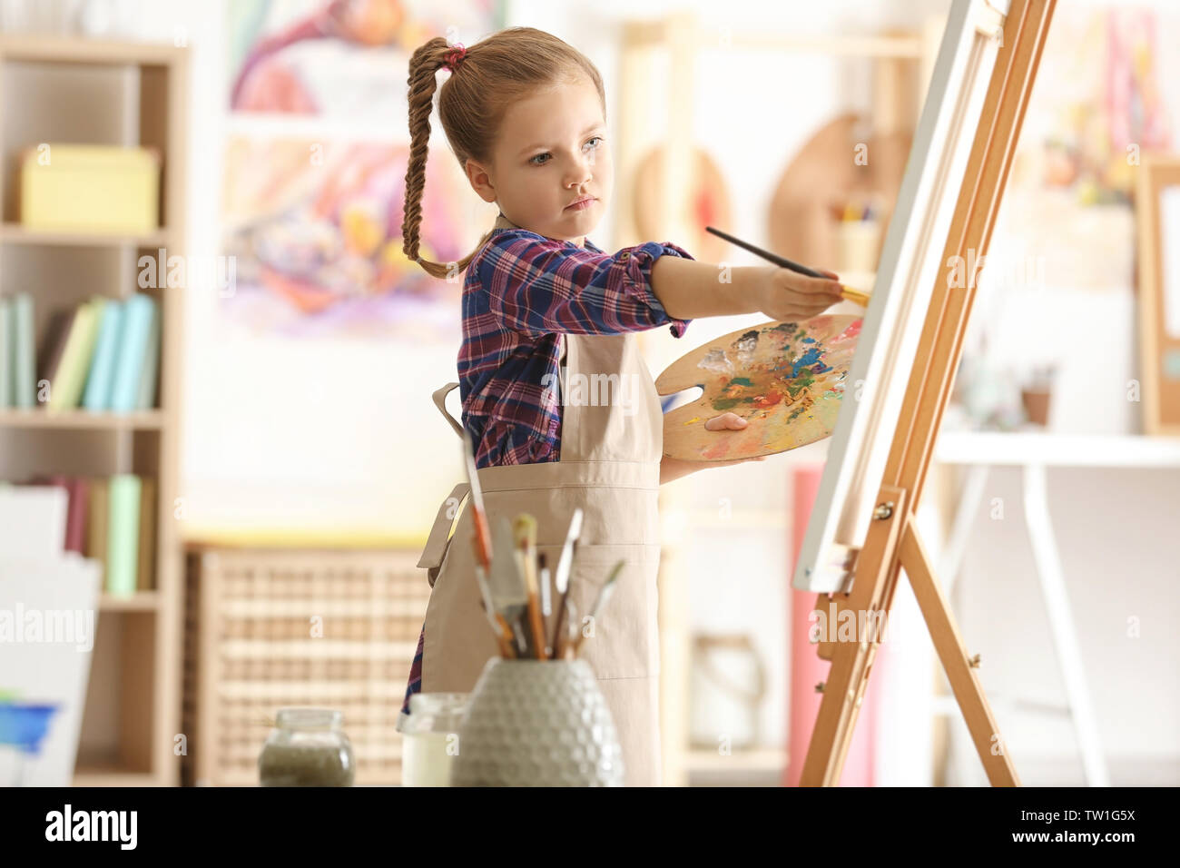 Cute little artist painting picture in studio Stock Photo - Alamy