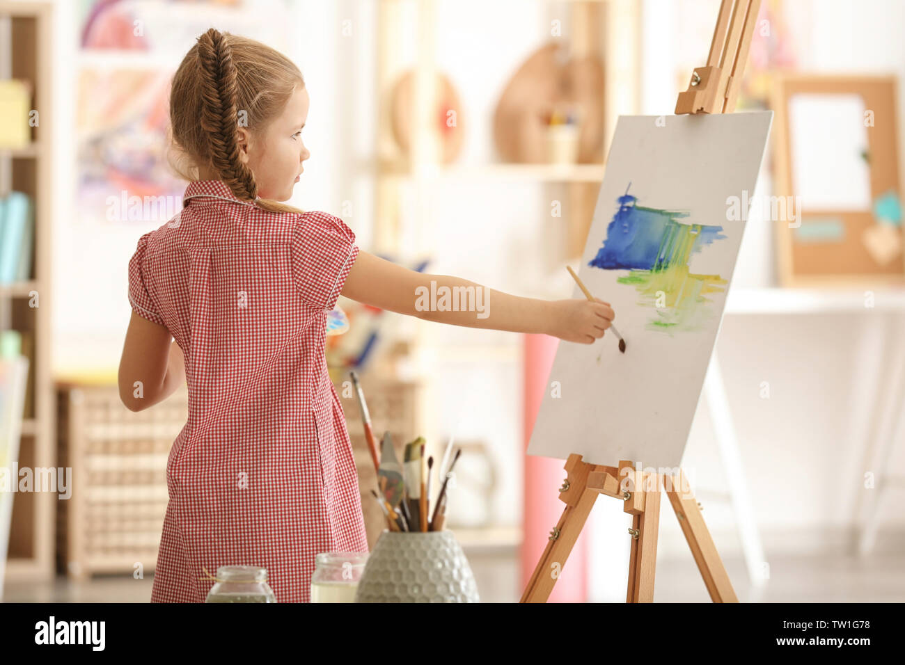 Cute little artist painting picture in studio Stock Photo - Alamy