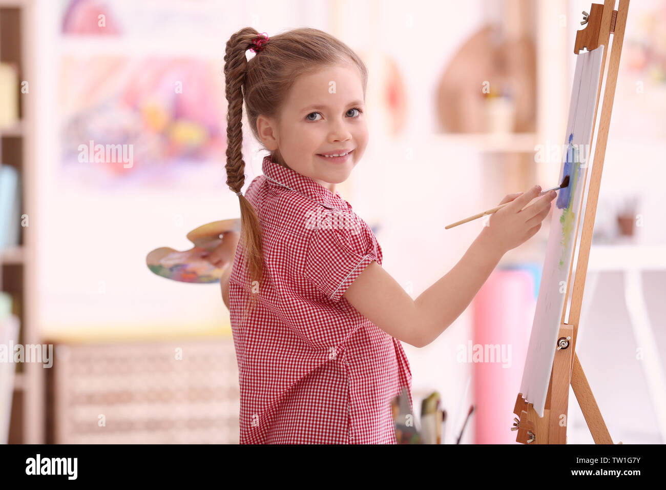 Cute little artist painting picture in studio Stock Photo - Alamy