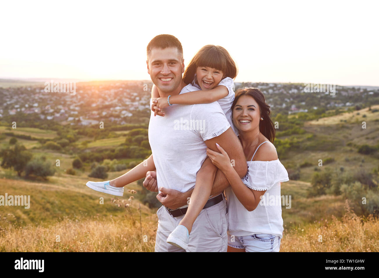 A cheerful family is smiling in the sunset Stock Photo - Alamy