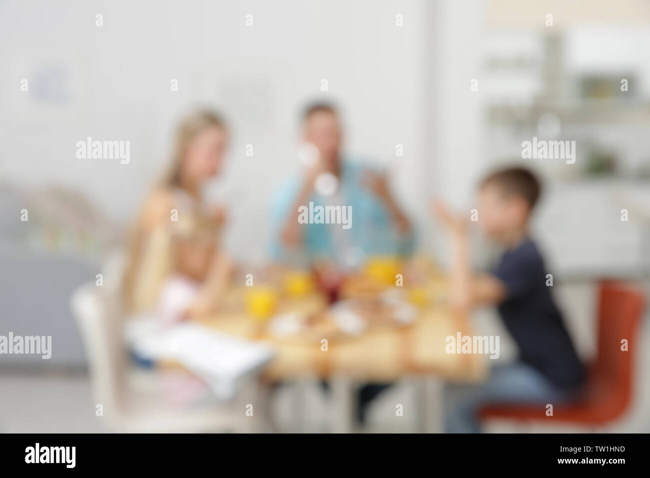 Blurred background of family having breakfast on kitchen Stock Photo ...