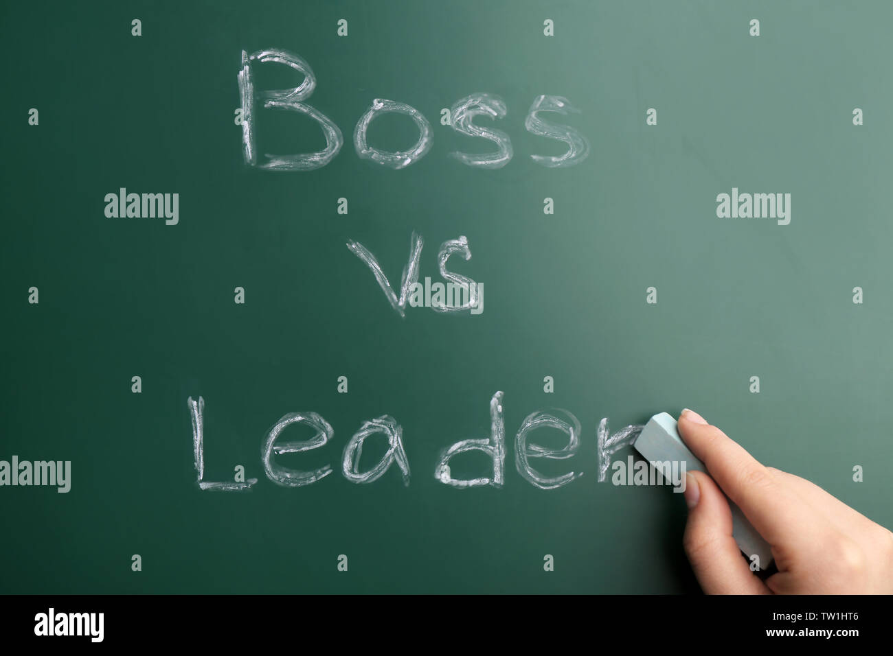 Female hand with chalk and words BOSS VS LEADER on chalkboard Stock ...
